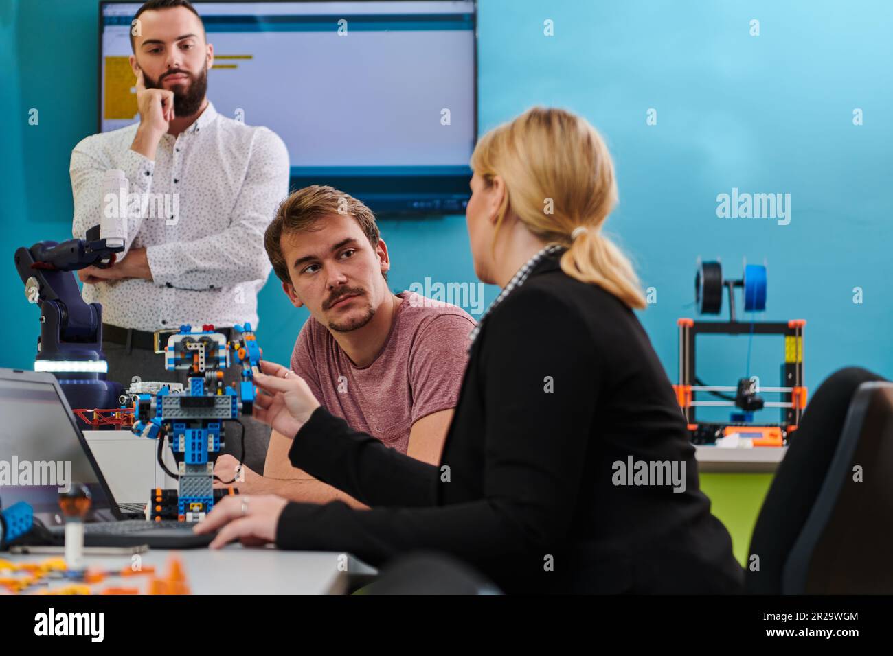A group of colleagues working together in a robotics laboratory ...