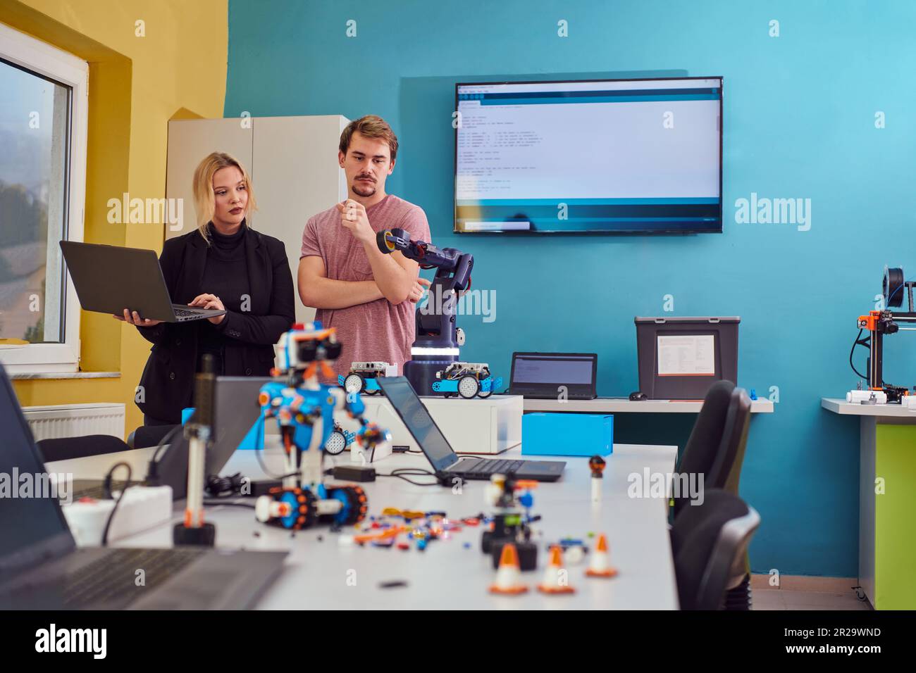 A group of colleagues working together in a robotics laboratory ...
