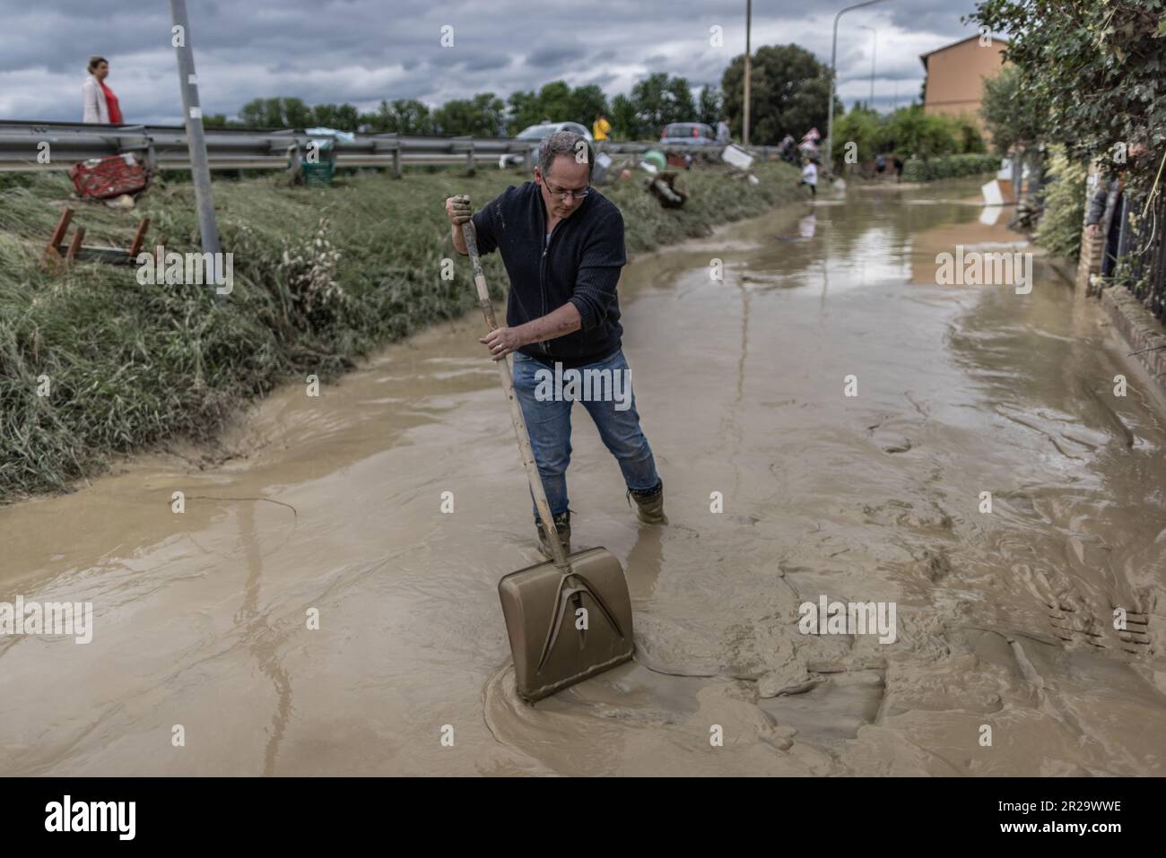 Faenza, Italy. 18th May, 2023. A local resident tries to clean a street ...