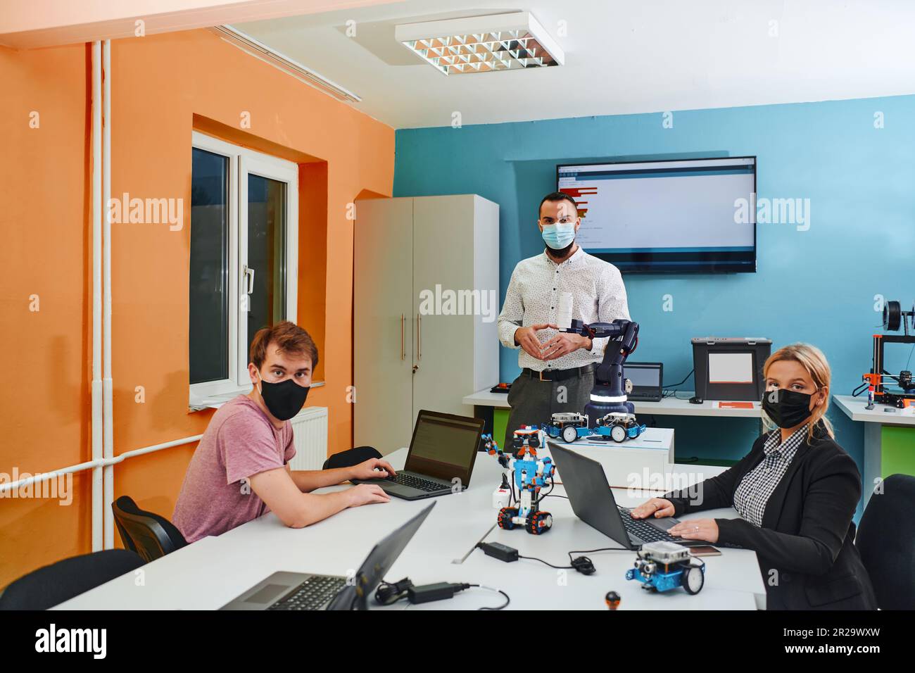 A group of colleagues working together in a robotics laboratory ...