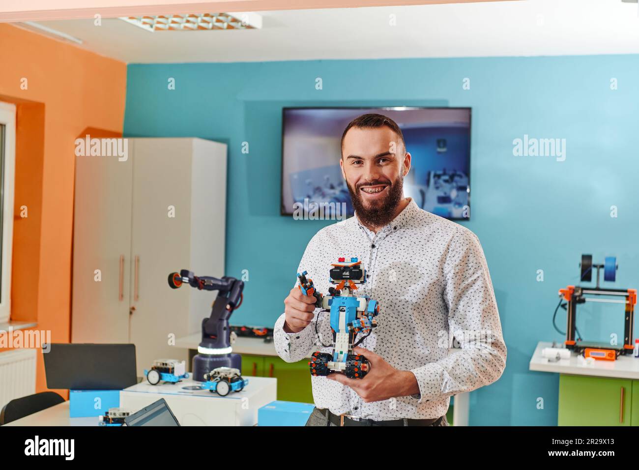 A man working in a robotics laboratory, focusing on the intricate ...