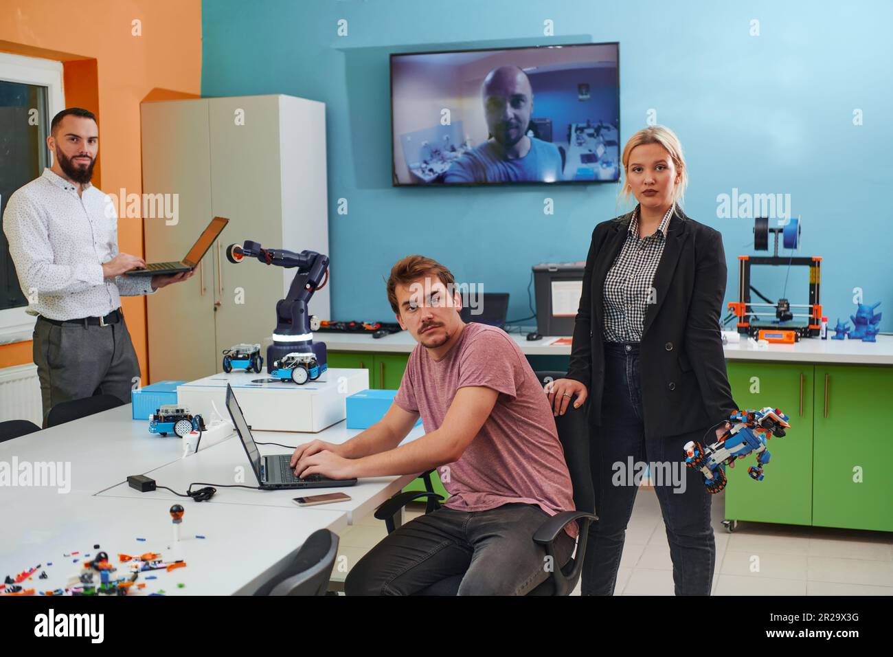 A group of colleagues working together in a robotics laboratory ...