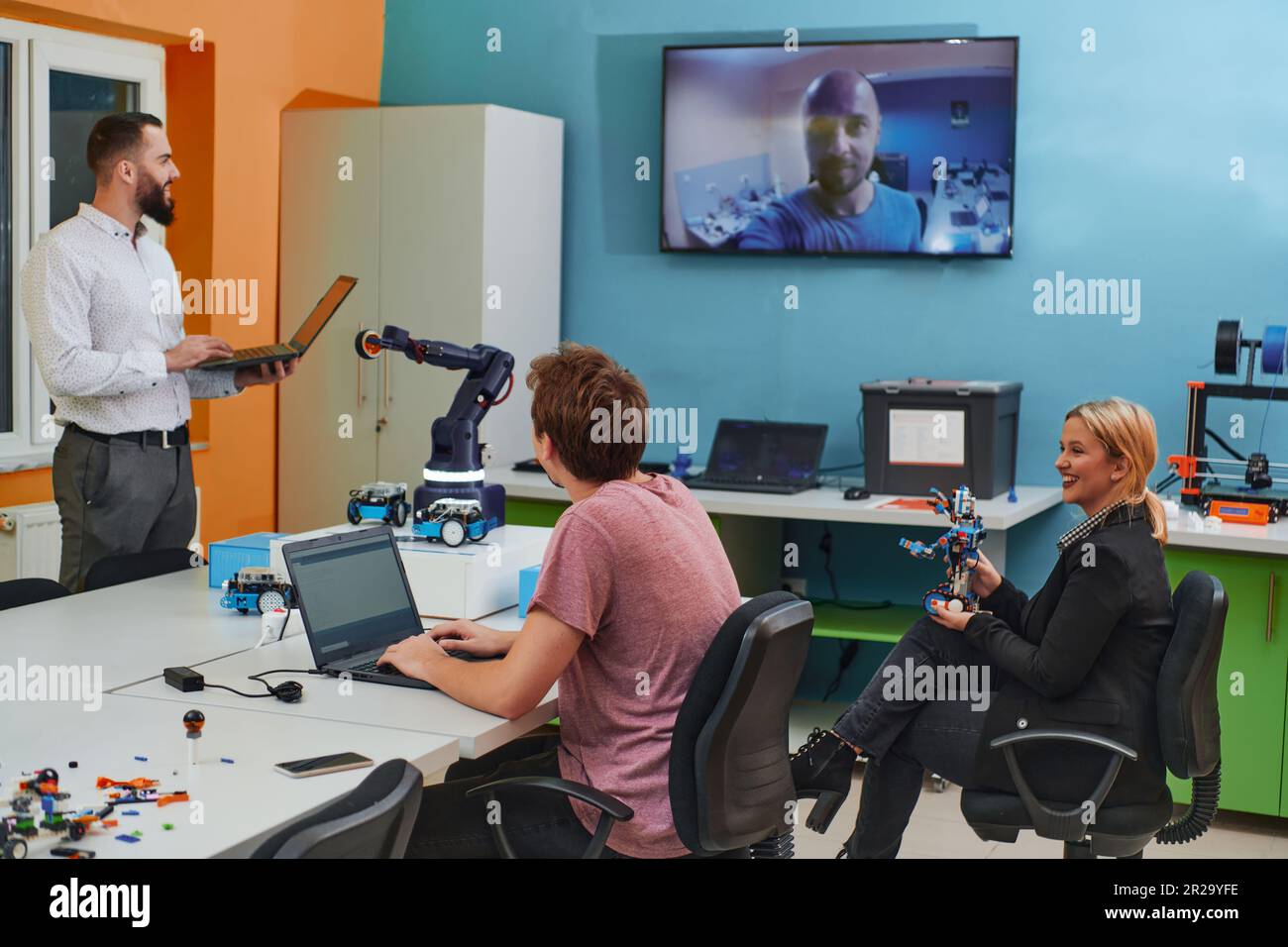 A group of colleagues working together in a robotics laboratory ...