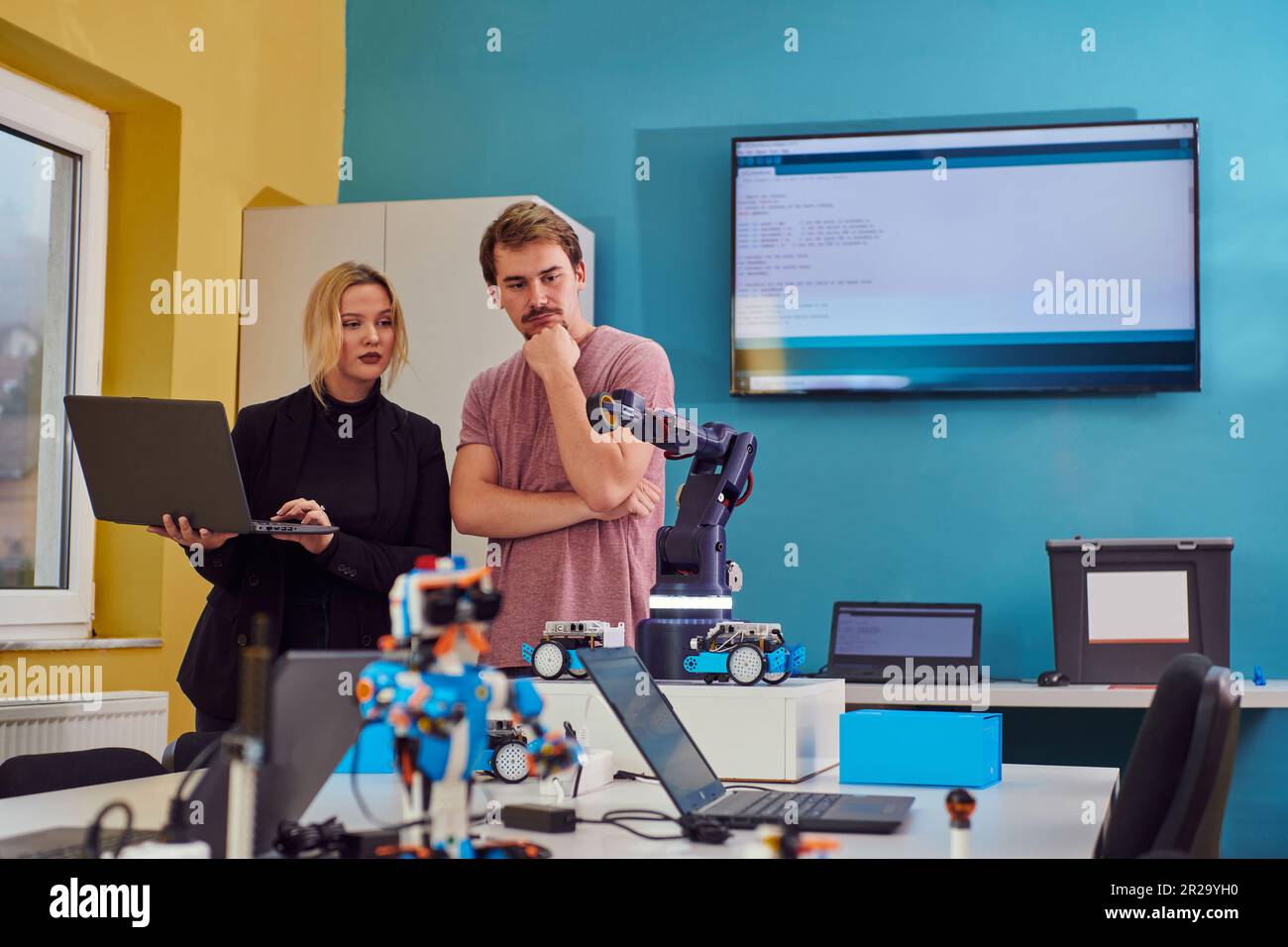 A group of colleagues working together in a robotics laboratory ...
