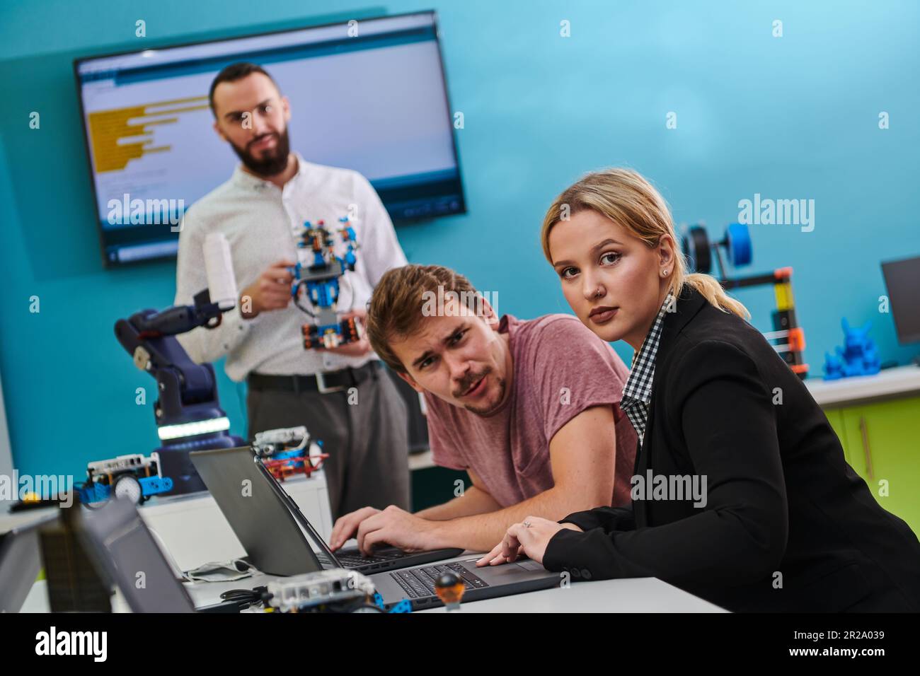 A group of colleagues working together in a robotics laboratory ...