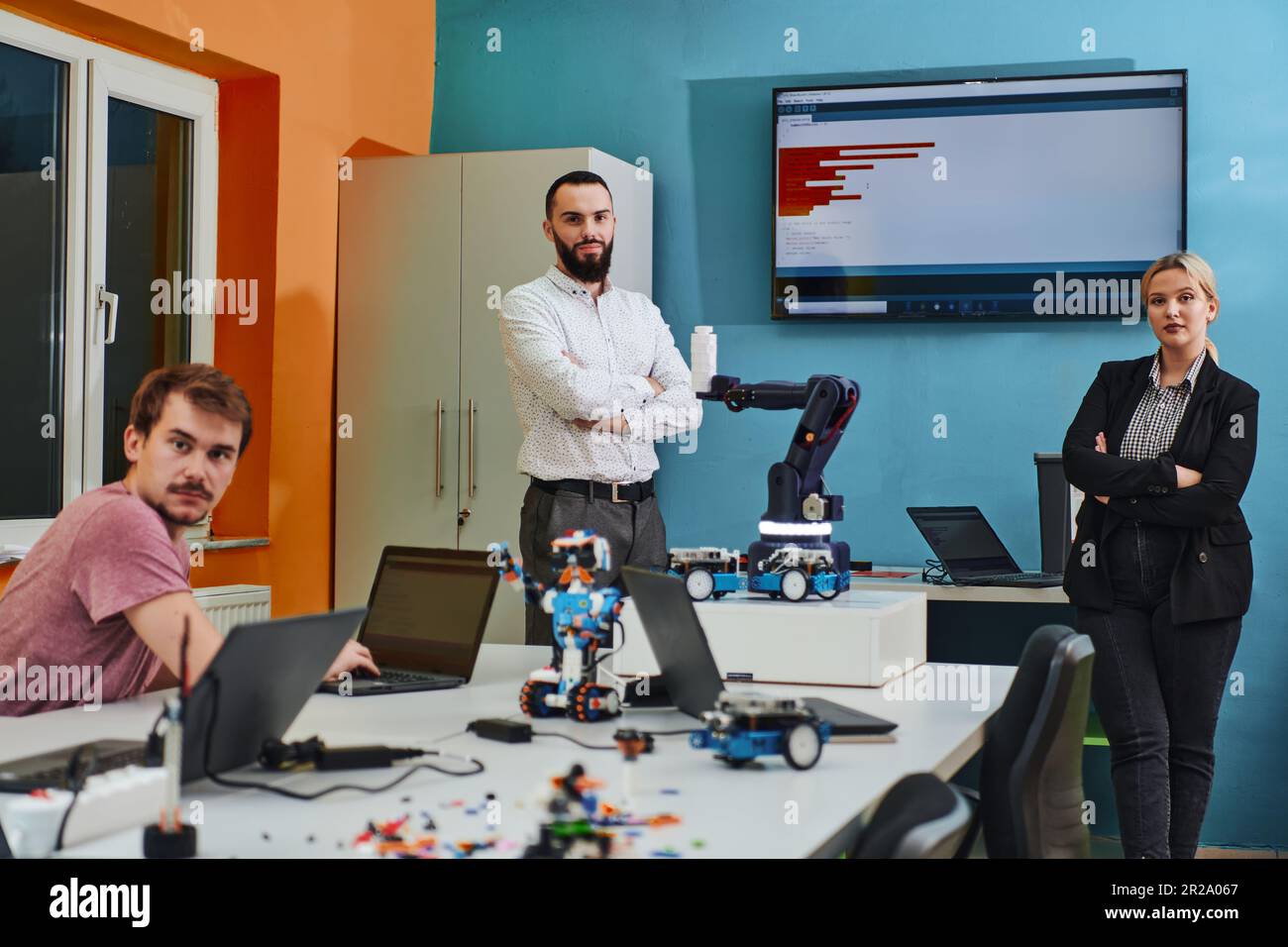 A group of colleagues working together in a robotics laboratory ...