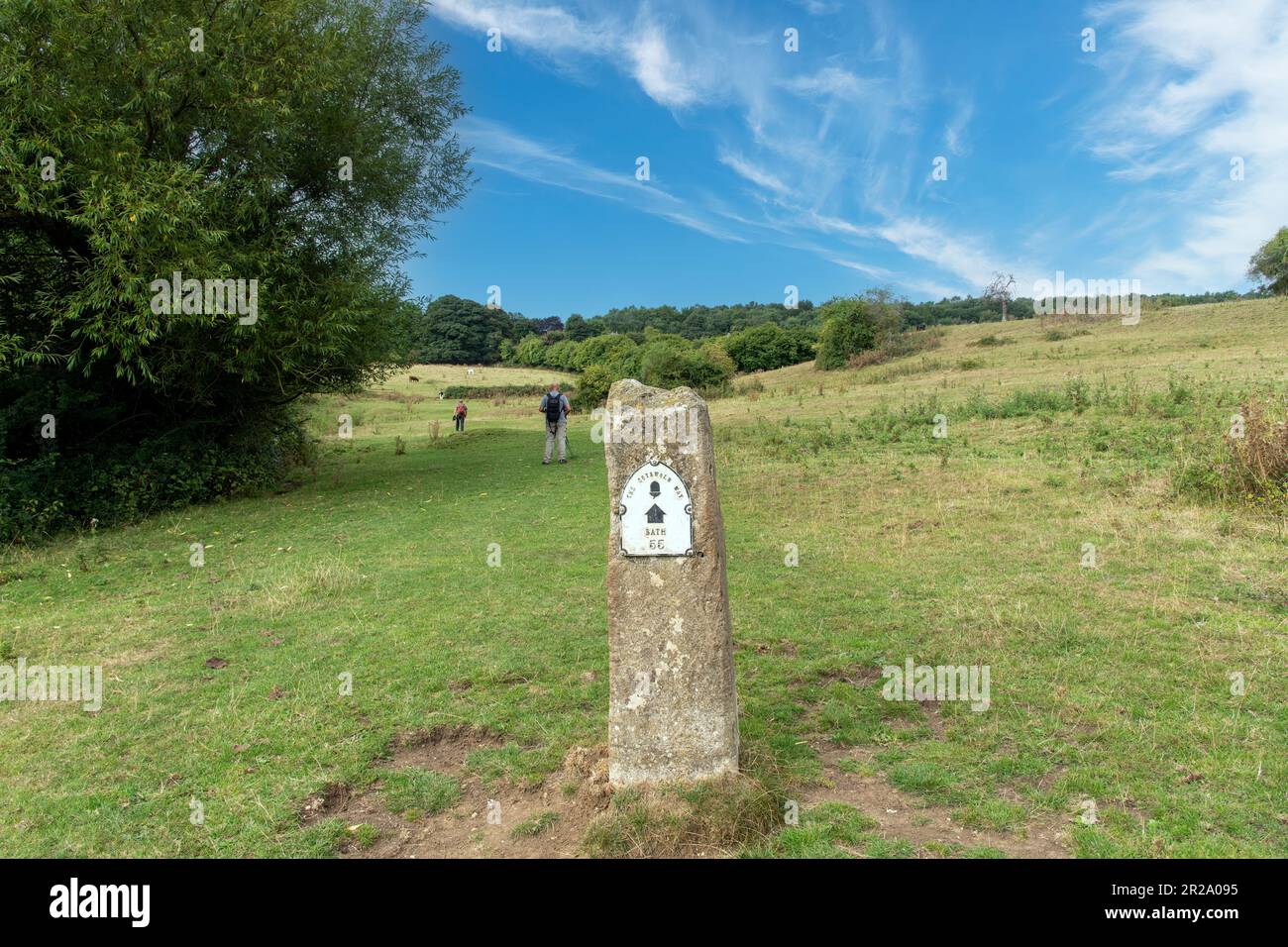 View over hilly landscape with hikers in the Cotswolds with stone ...