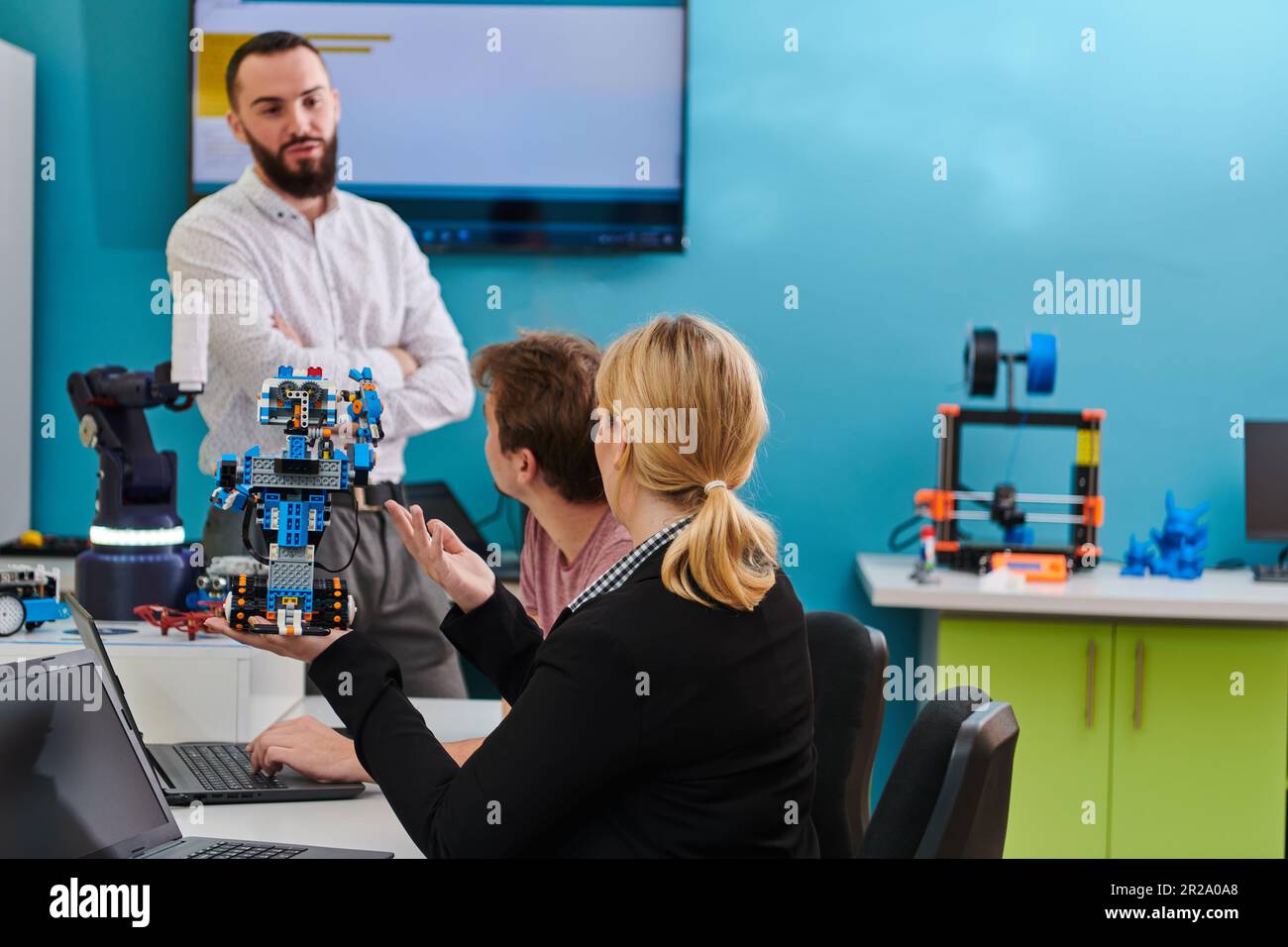 A group of colleagues working together in a robotics laboratory ...