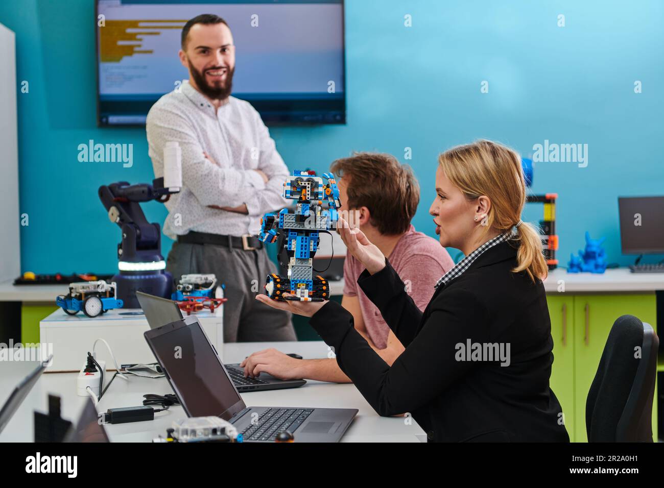 A group of colleagues working together in a robotics laboratory ...