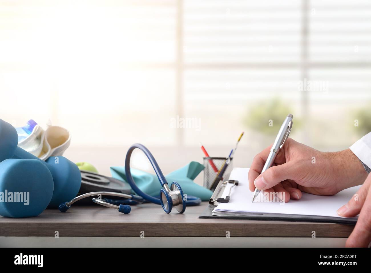 Physiotherapist doctor taking notes on office table with medical ...