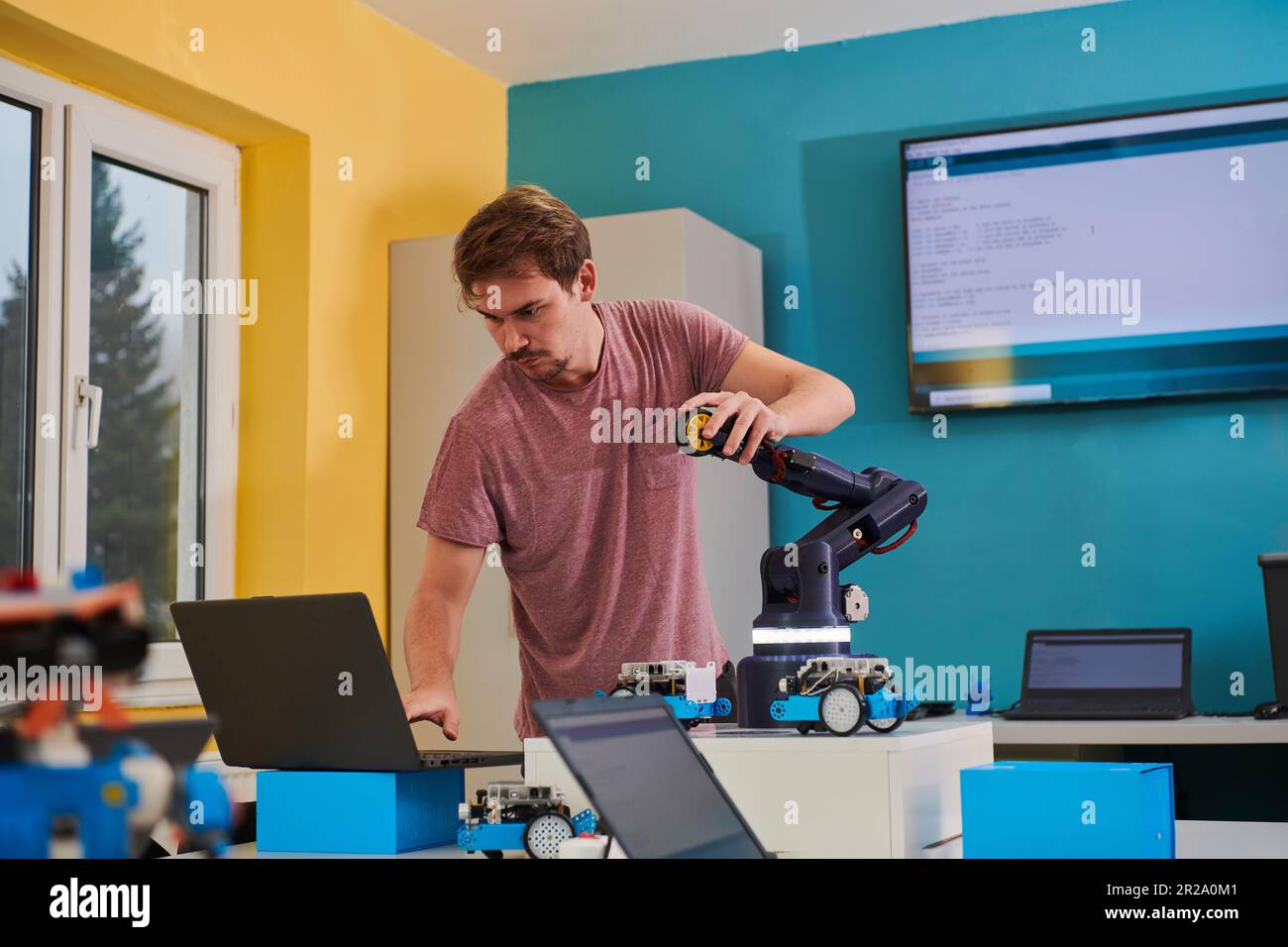 A student testing his new invention of a robotic arm in the laboratory ...