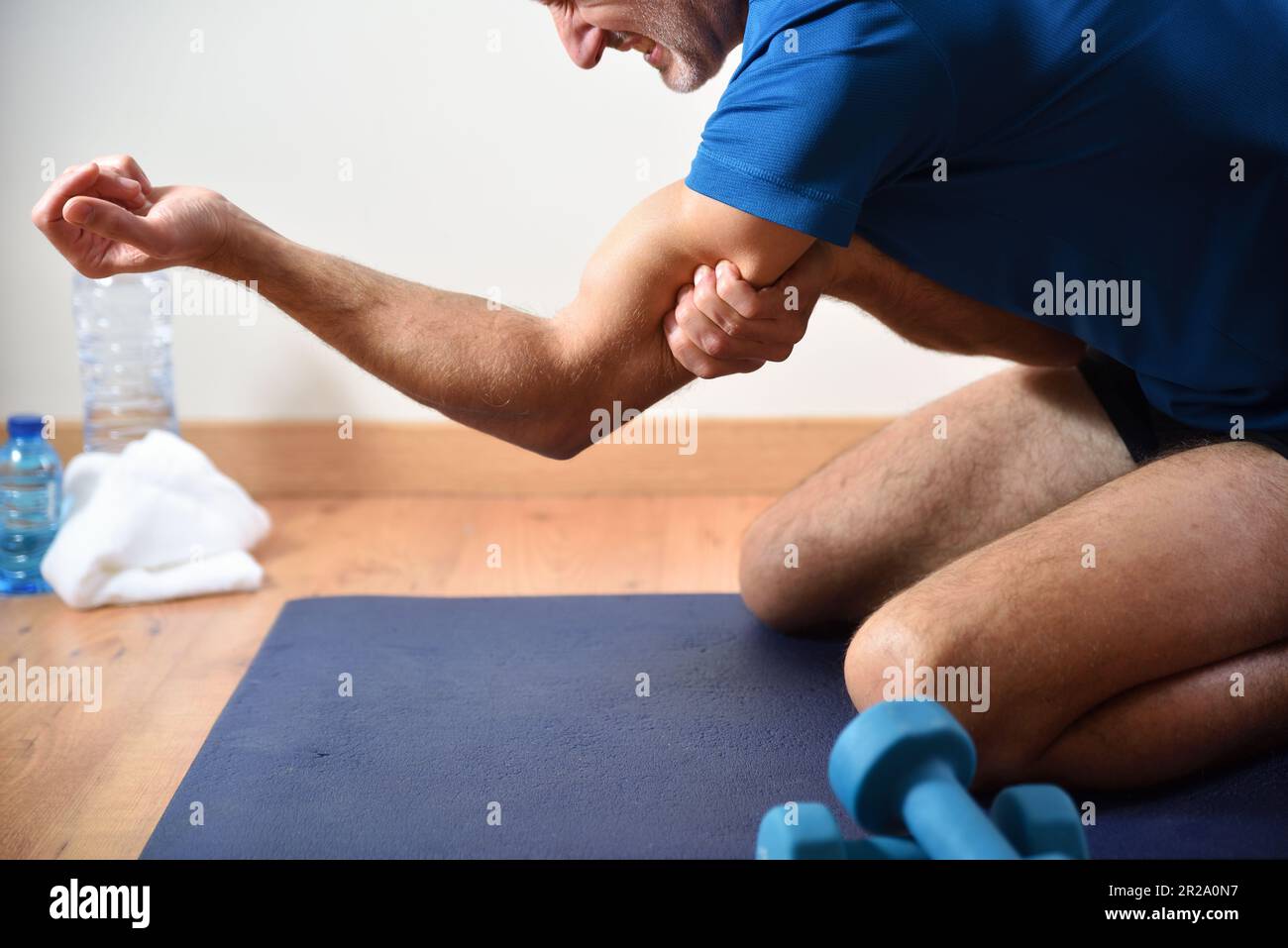 Detail of man doing sports with triceps pain holding himself with his ...
