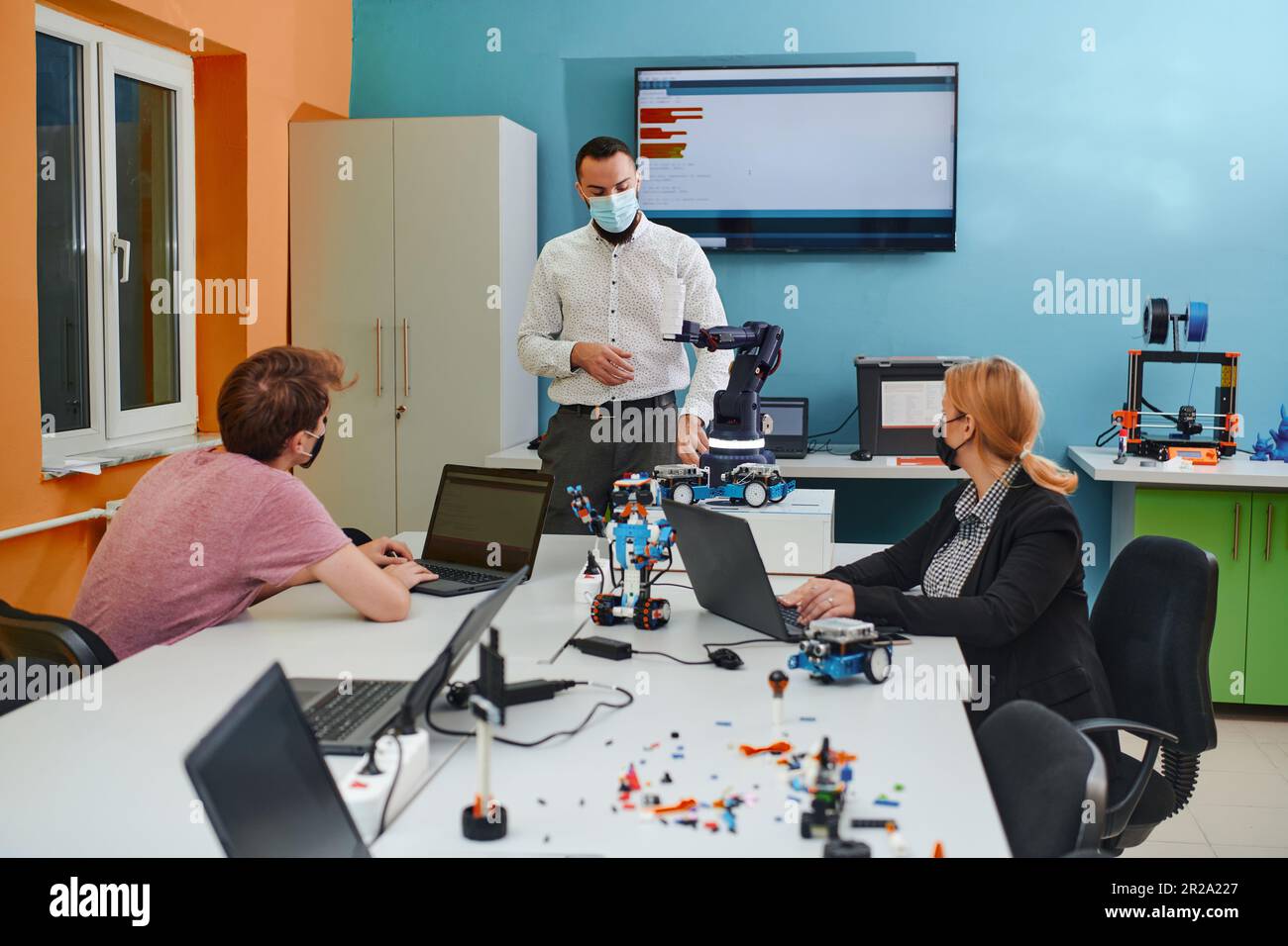A group of colleagues working together in a robotics laboratory ...