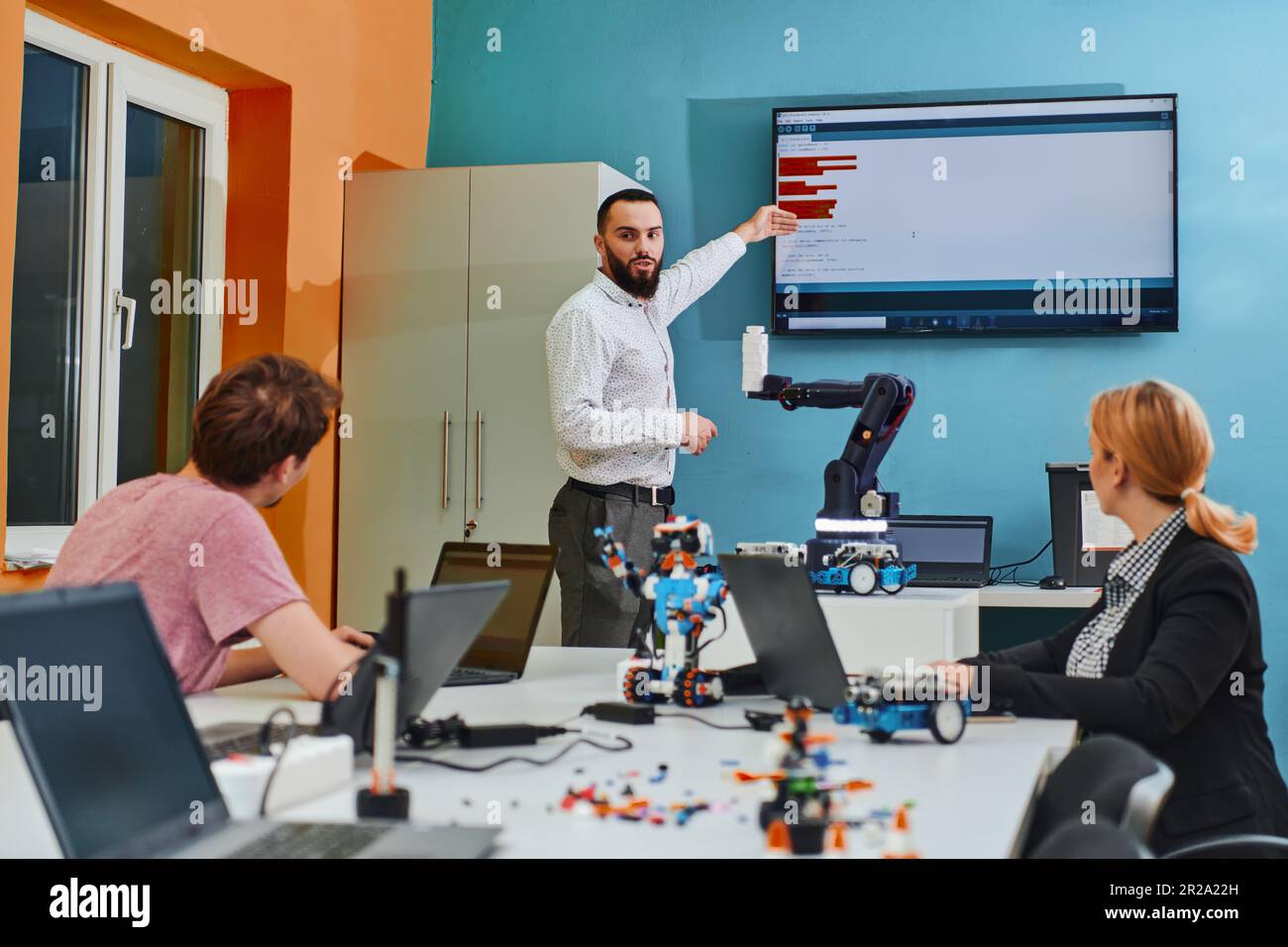 A group of colleagues working together in a robotics laboratory ...