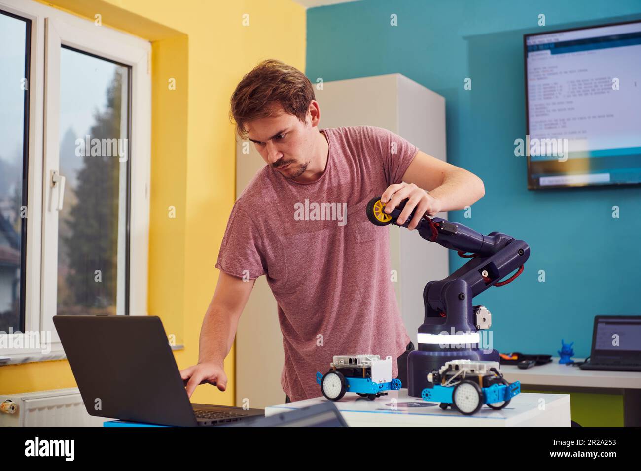 A student testing his new invention of a robotic arm in the laboratory ...