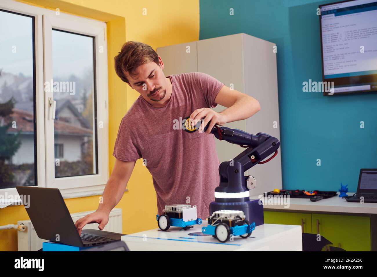 A student testing his new invention of a robotic arm in the laboratory ...