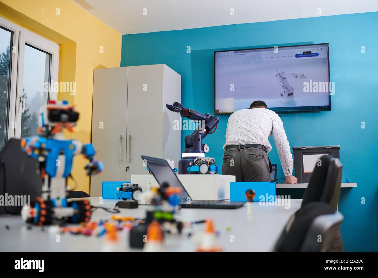 A student testing his new invention of a robotic arm in the laboratory ...