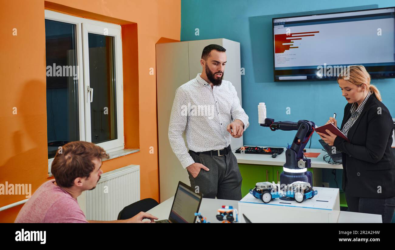 A group of colleagues working together in a robotics laboratory ...