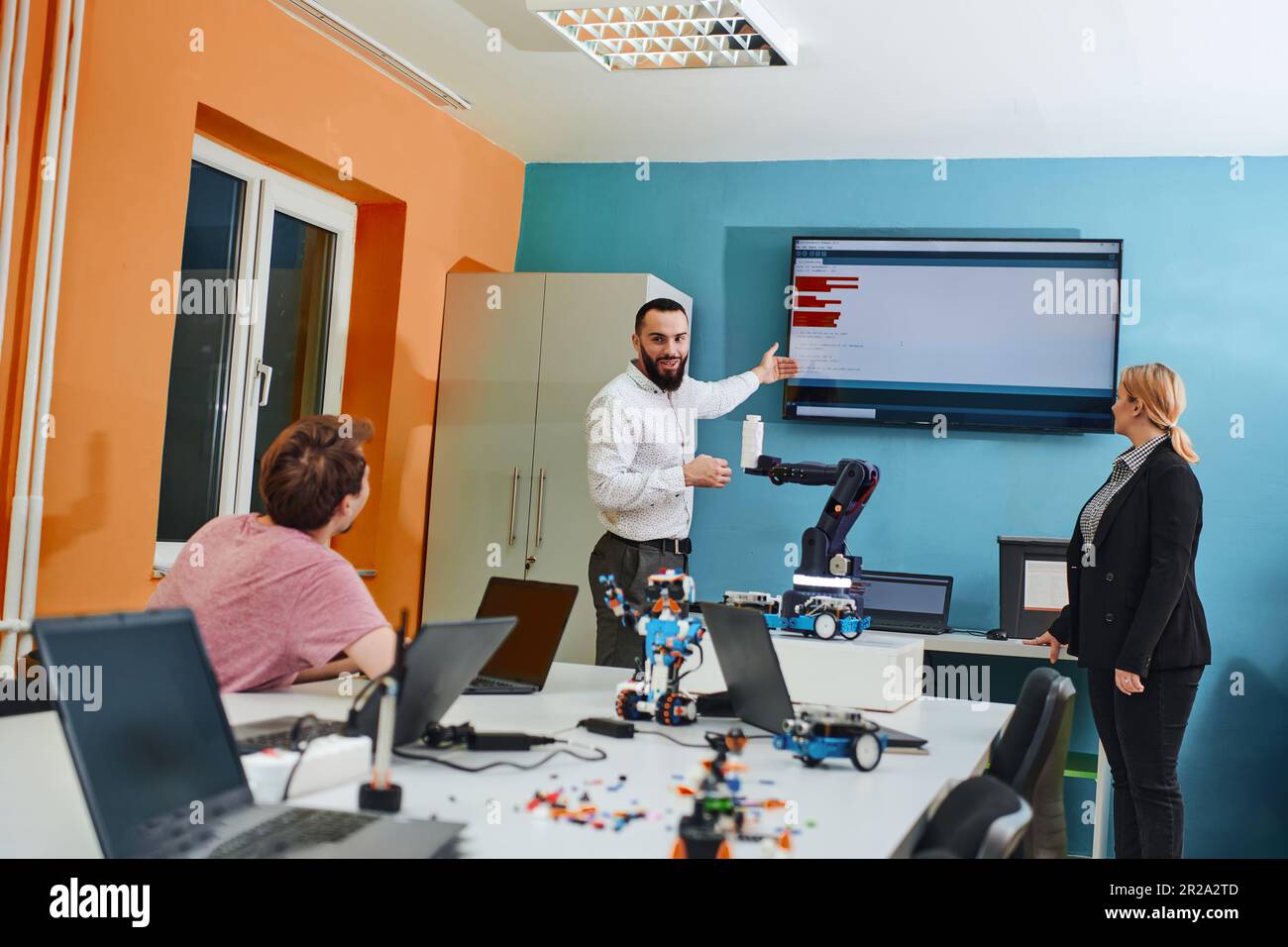 A group of colleagues working together in a robotics laboratory ...