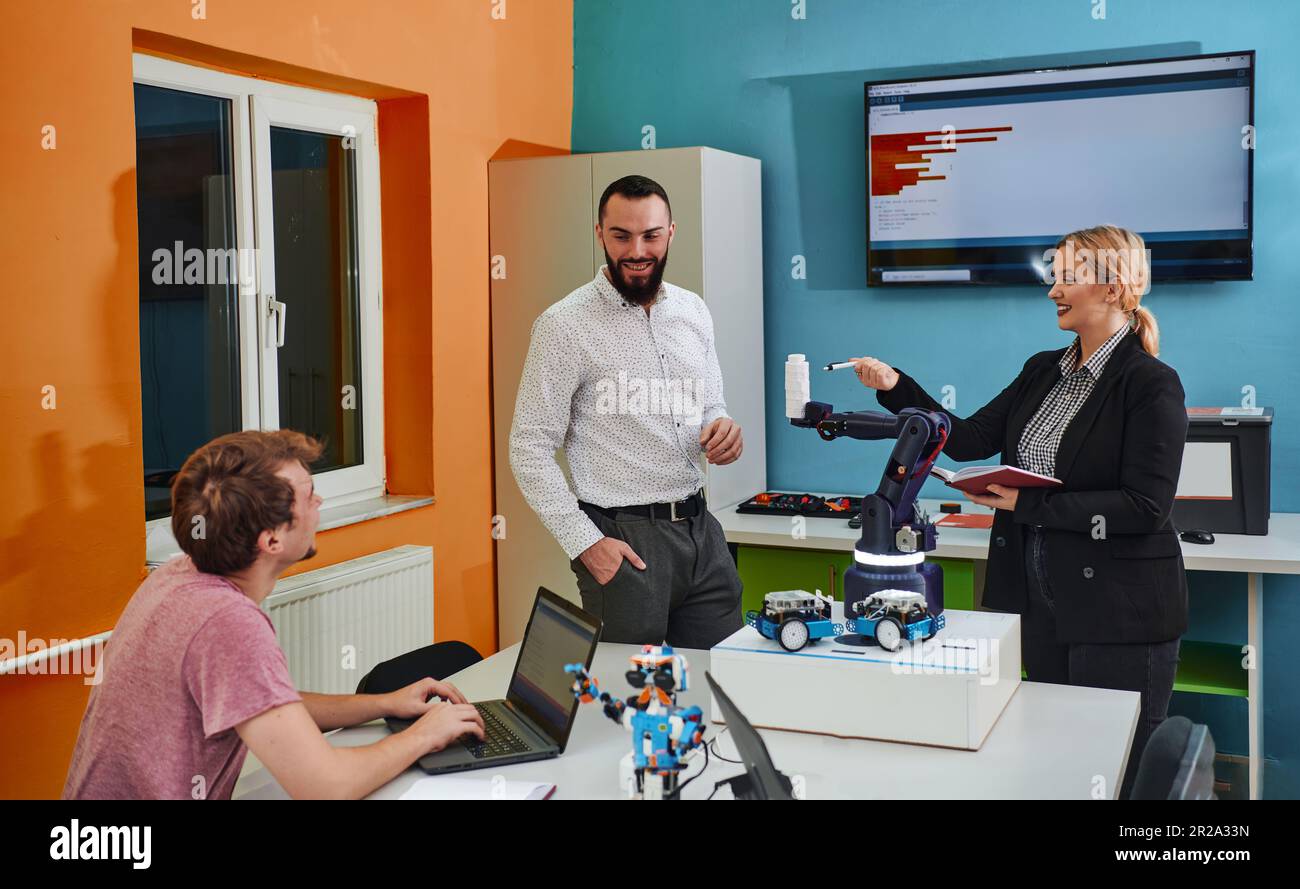 A group of colleagues working together in a robotics laboratory ...