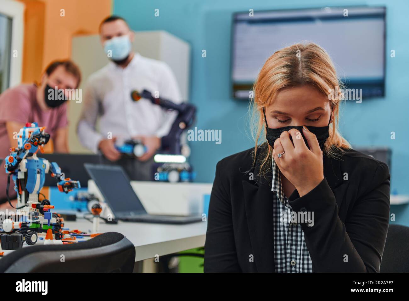 A woman wearing a protective mask standing in a laboratory while her ...