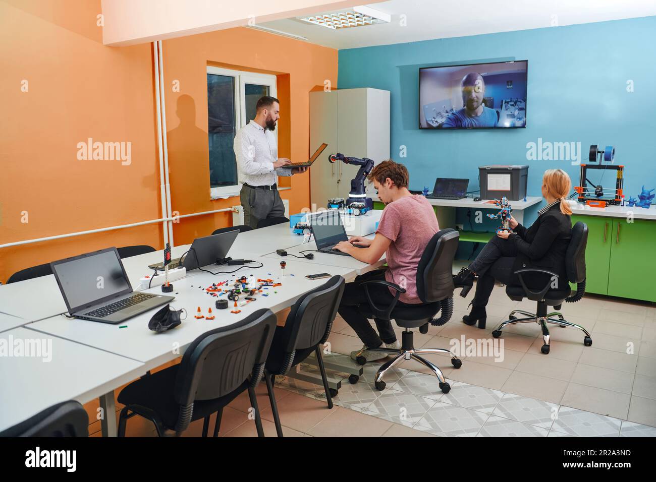 A group of colleagues working together in a robotics laboratory ...