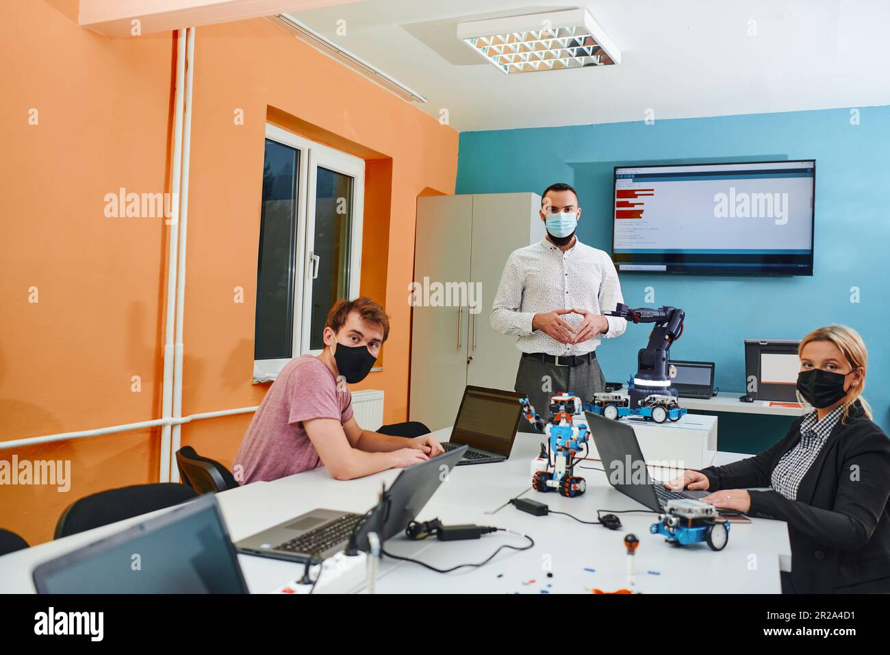 A group of colleagues working together in a robotics laboratory ...