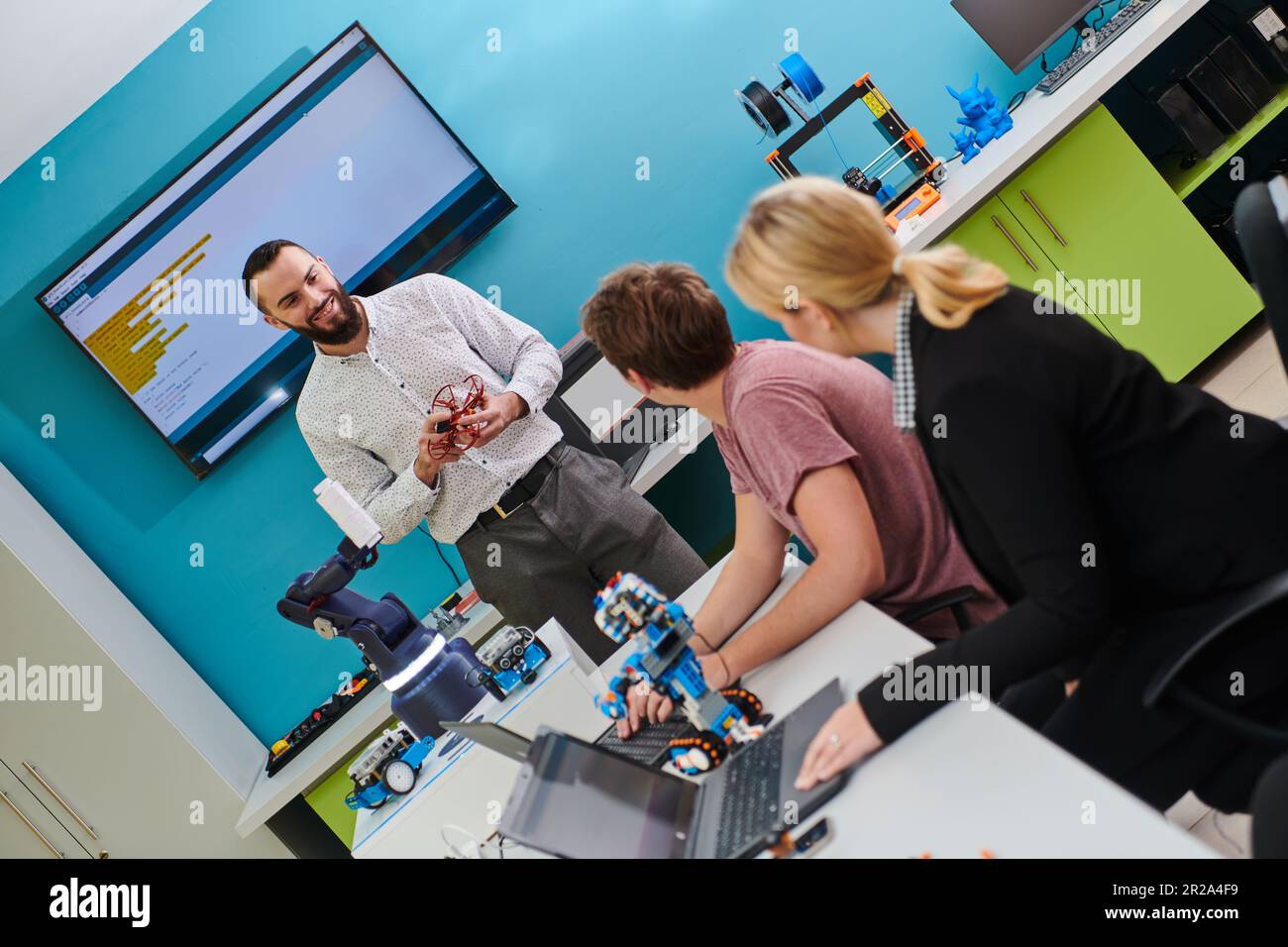 A group of colleagues working together in a robotics laboratory ...