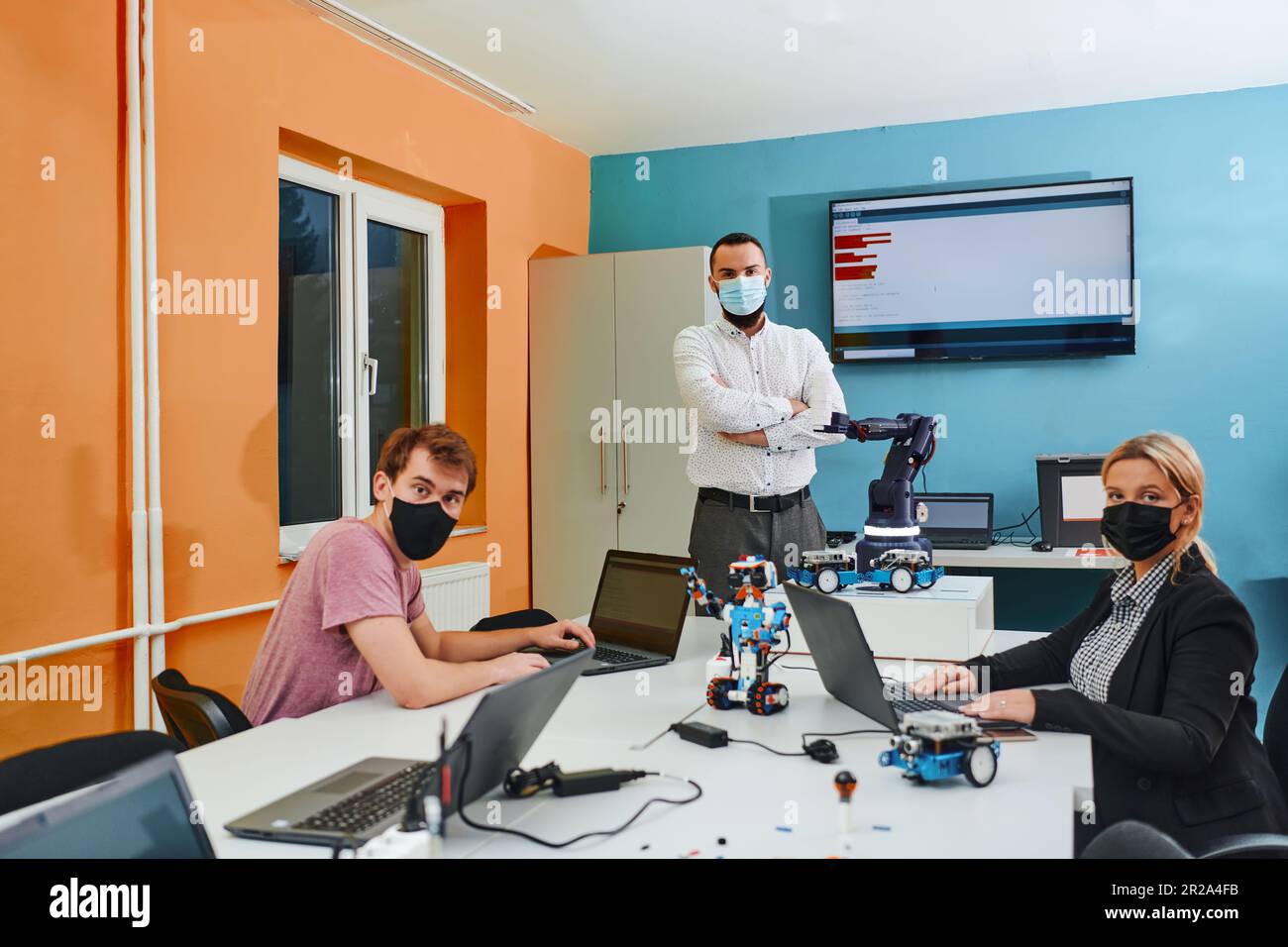A group of colleagues working together in a robotics laboratory ...