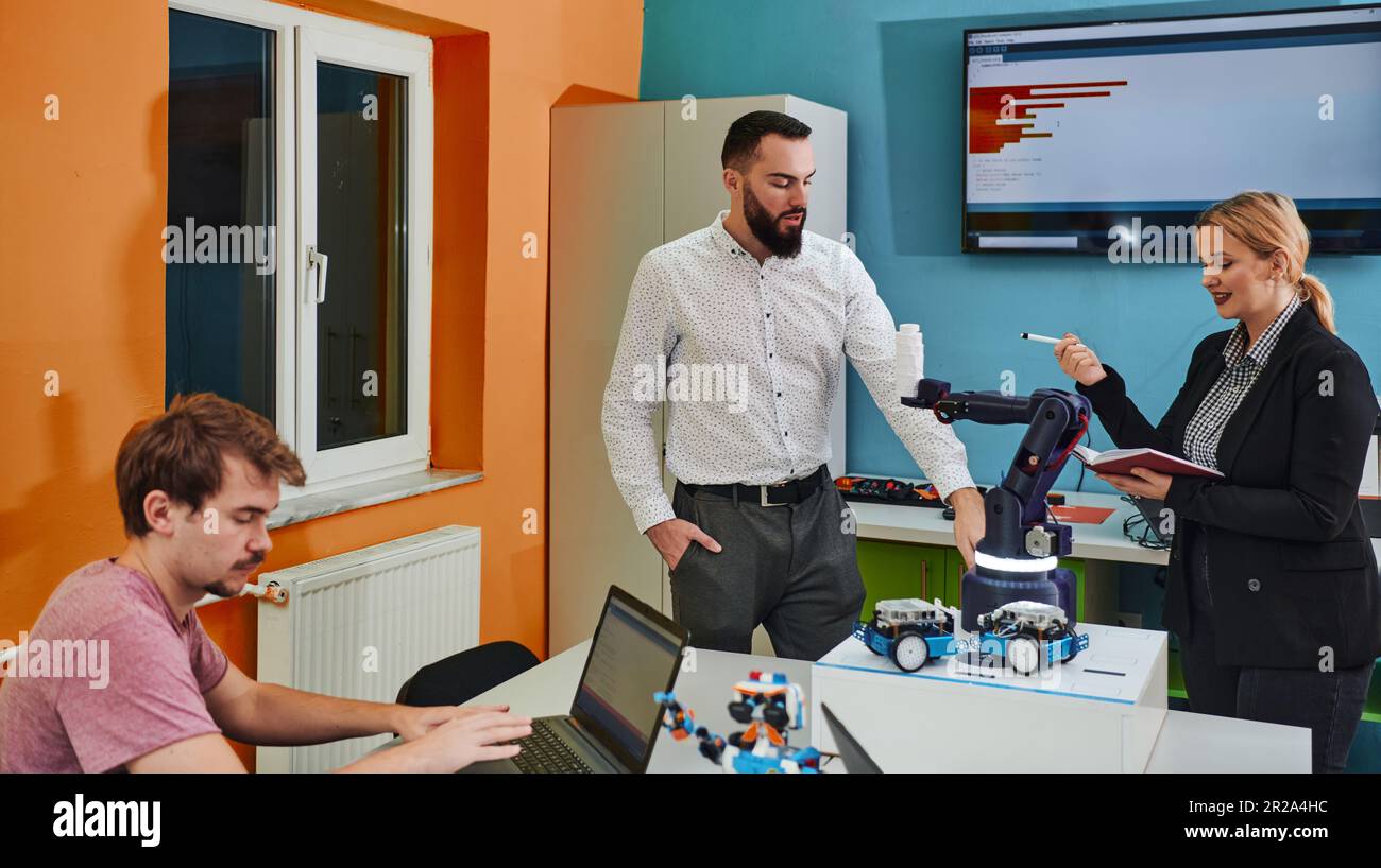A group of colleagues working together in a robotics laboratory ...