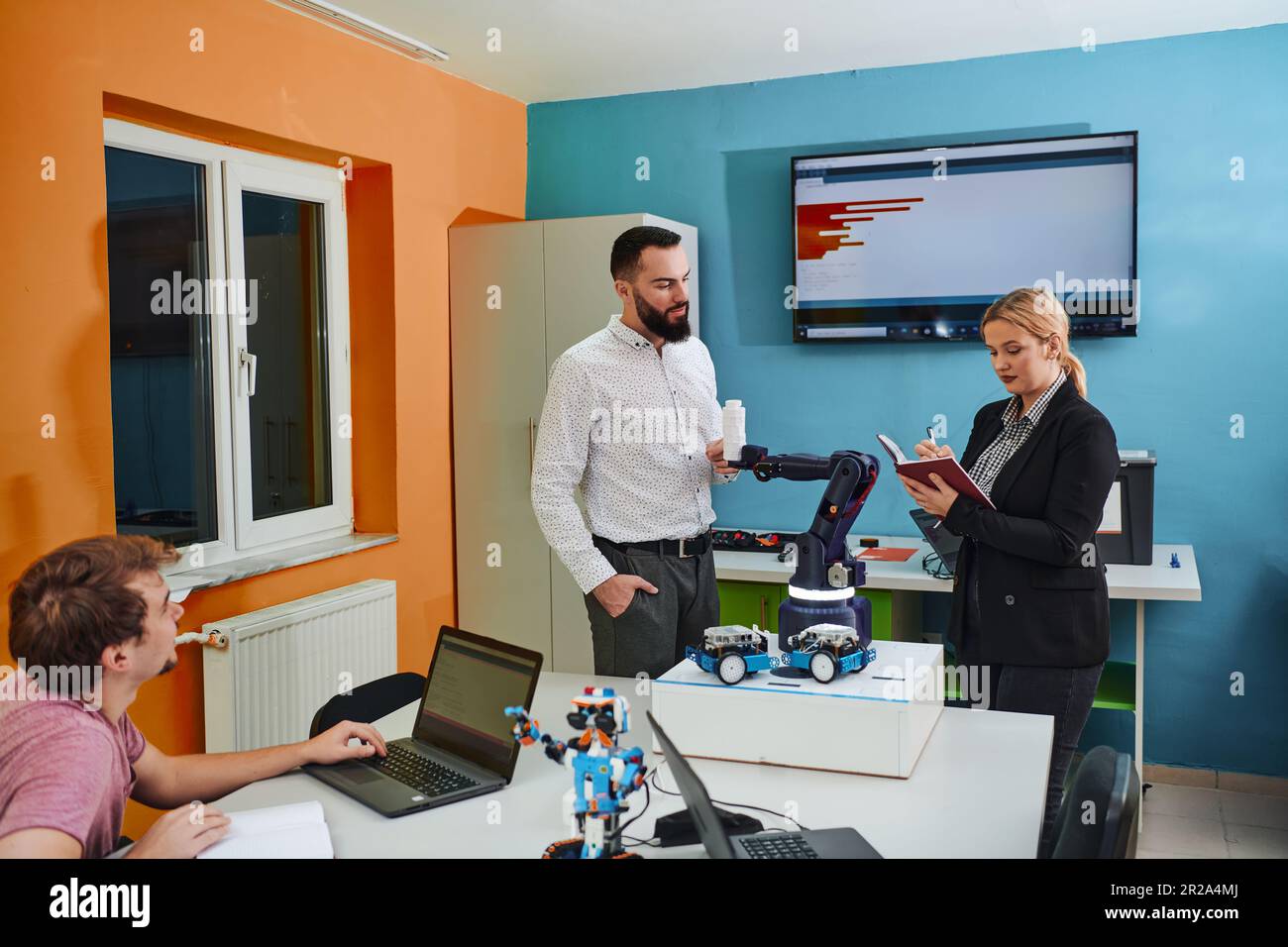 A group of colleagues working together in a robotics laboratory ...