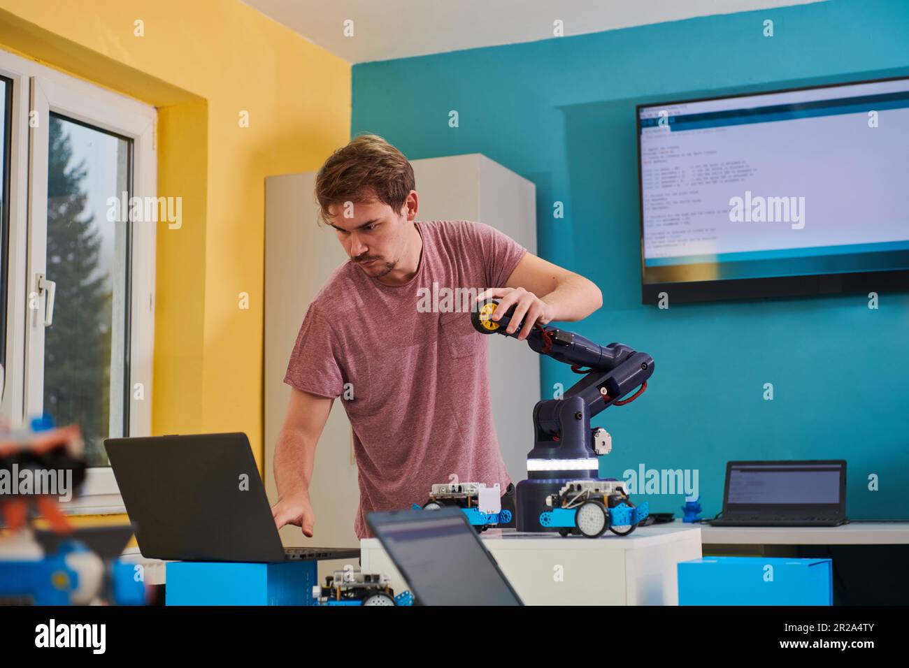 A student testing his new invention of a robotic arm in the laboratory ...