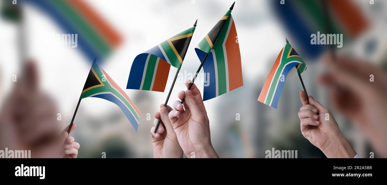 A group of people holding small flags of the South Africa in their ...