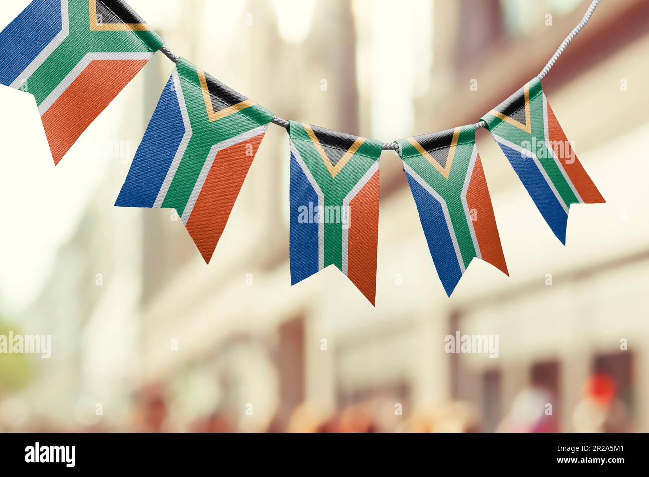 A garland of South Africa national flags on an abstract blurred ...