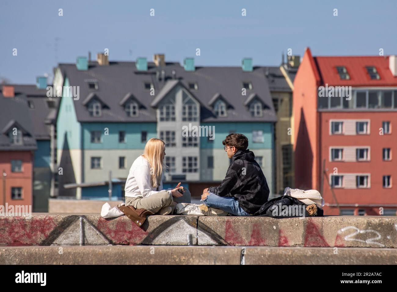 Young couple sitting on the edge of Linnahall with a backdrop of newly ...