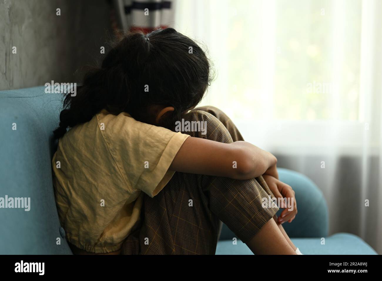 Lonely sad girl student crying and hug her knees sitting in corner ...