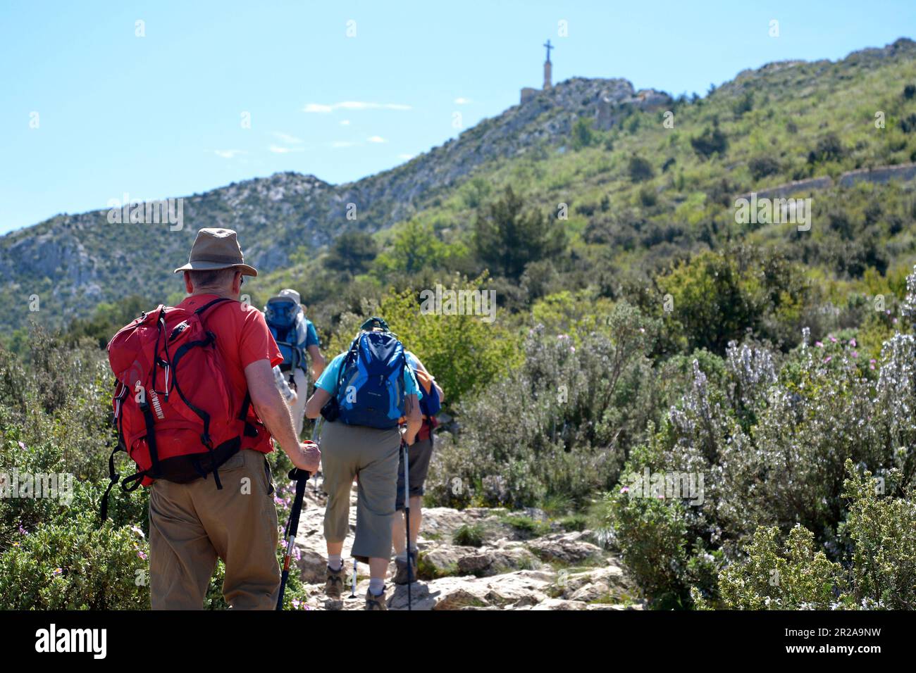 Hikers on the Ste Victoire mountain trail with the cross of Provence in ...