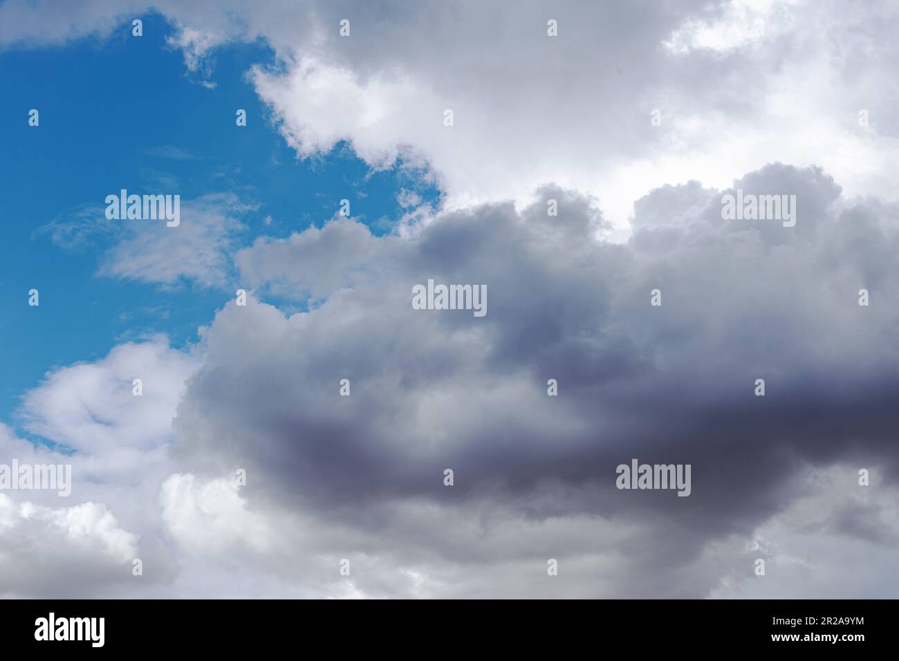 Storm cloud development on sunny day. Sky is blue, but change of ...