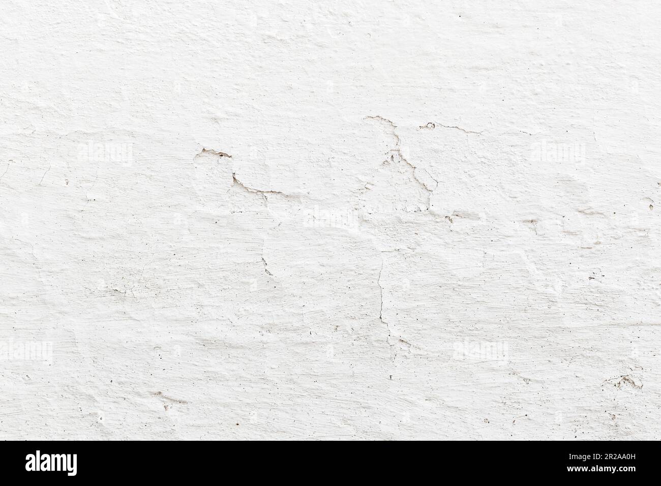 White wall of village house with paint cracked by passage of time ...