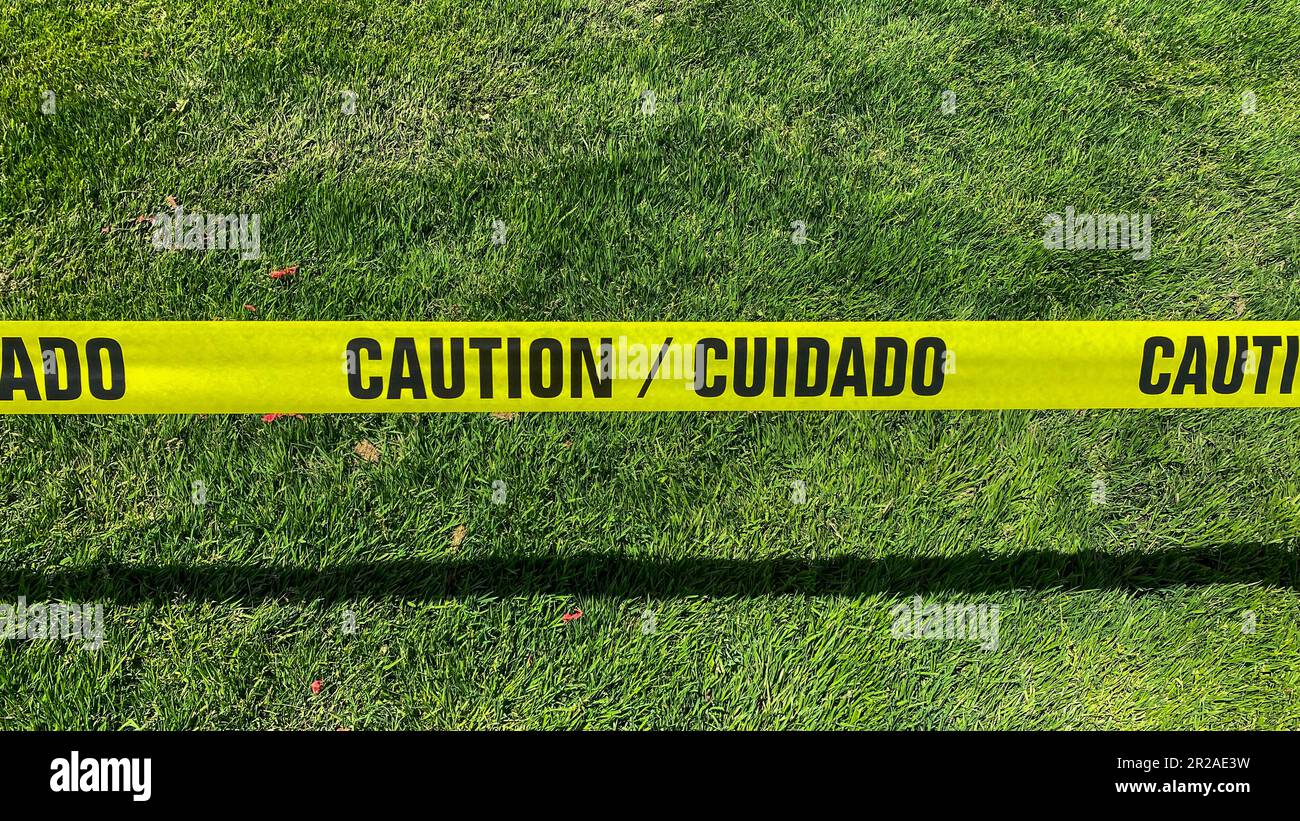 Horizontal view of yellow caution tape blocking entrance to a grass ...
