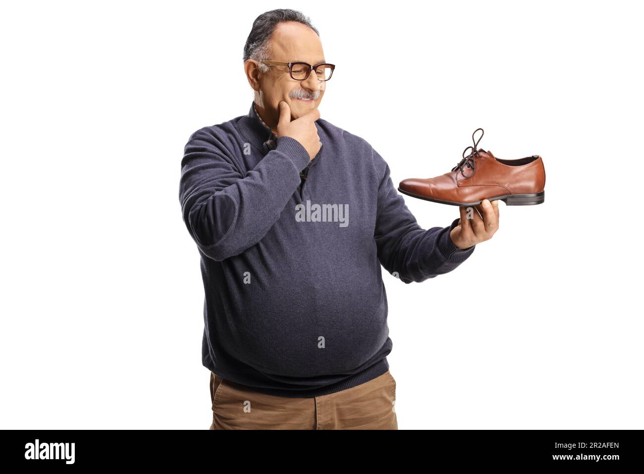 Mature man holding an elegant brown leather shoe and thinking isolated ...