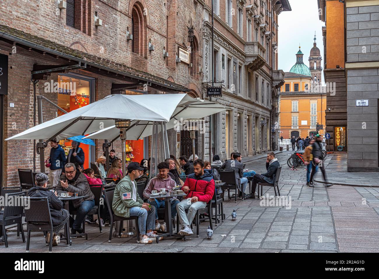 Tourists at the tables of the bar in Piazza del Monte under the Palazzo ...