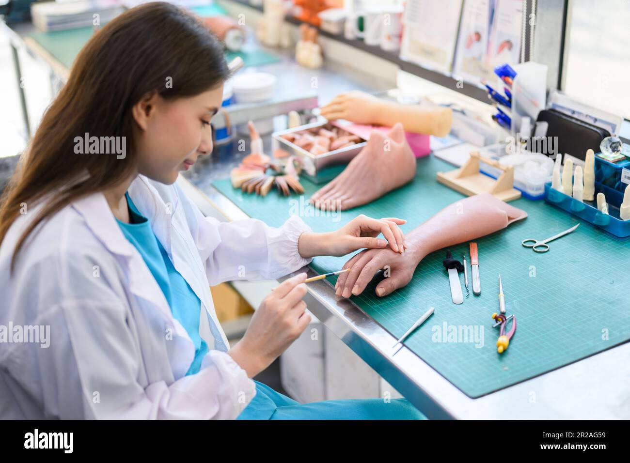 Technician making prosthetic device using grinder to smooth socket ...