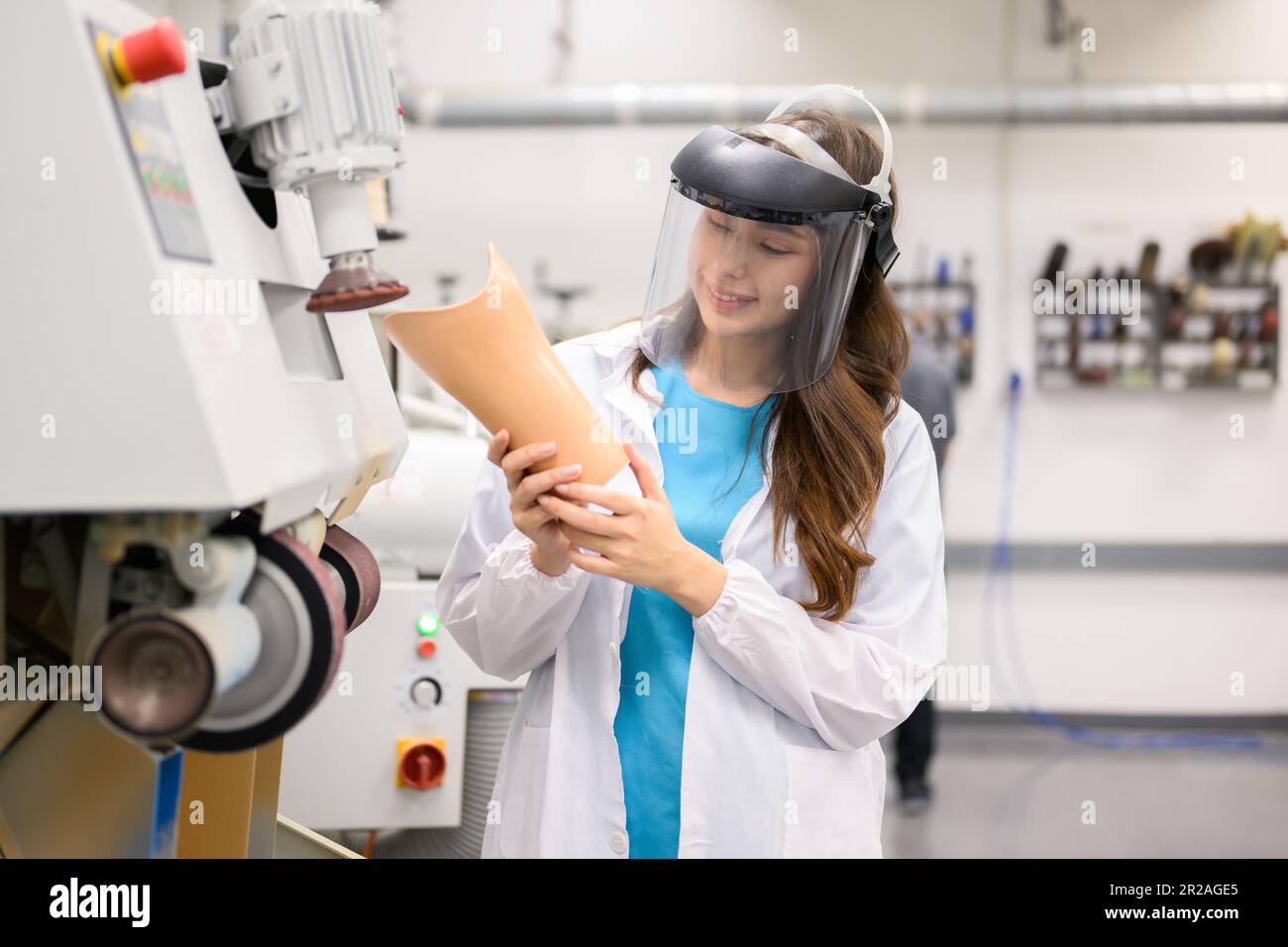 Technician making prosthetic device using grinder to smooth socket ...
