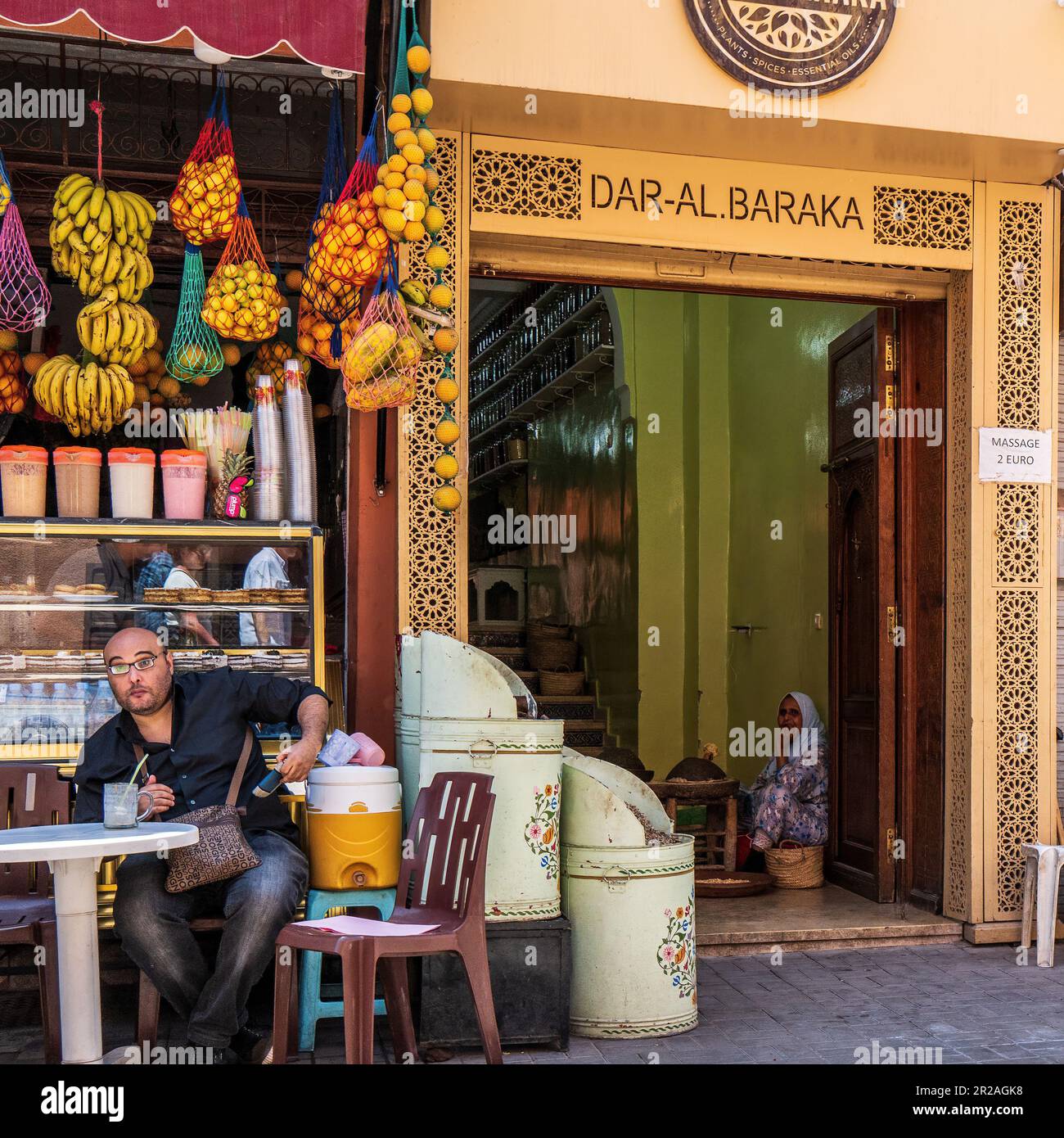 Man sitting outside a cafe in Marrakesh Medina, typical Moroccan street ...