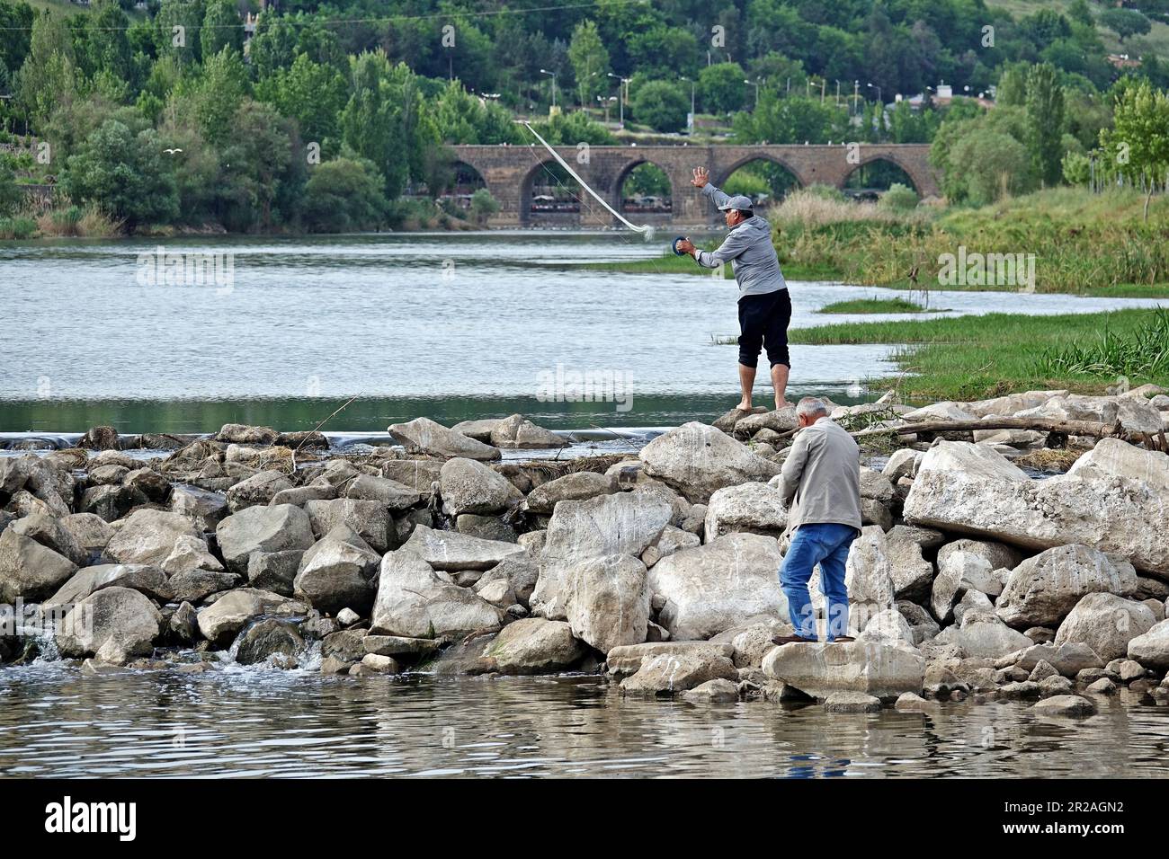 A fisherman is seen throwing his net in Tigris river. In Diyarbakir, it ...