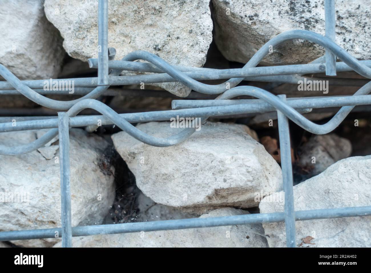 Steel gray wire around stones Stock Photo - Alamy