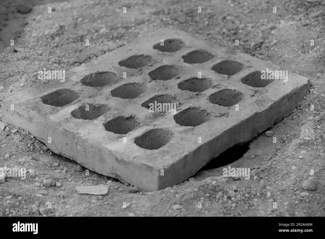 Concrete manhole cover on a sand Stock Photo - Alamy