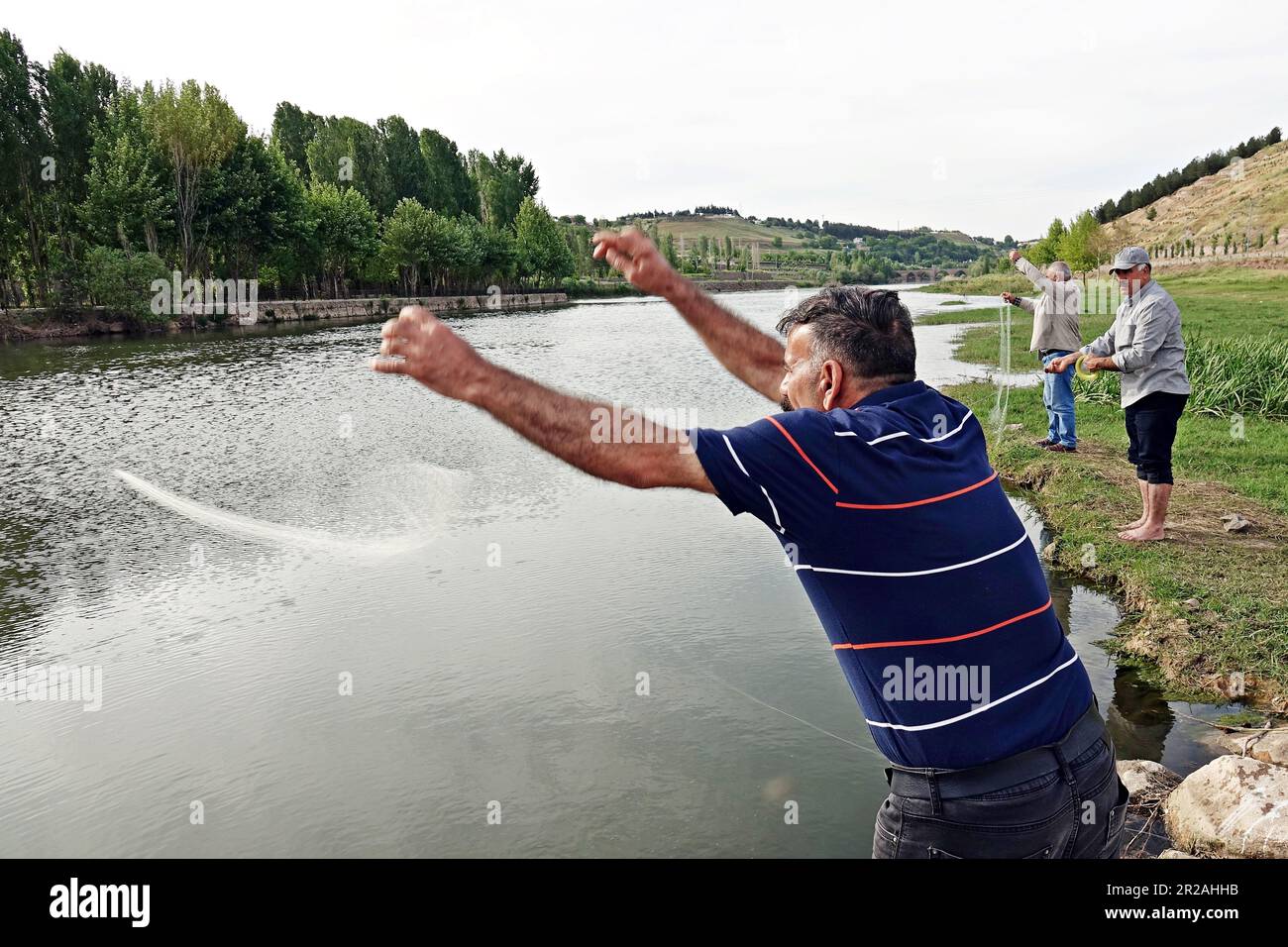 A fisherman is seen throwing his net in Tigris river. In Diyarbakir, it ...