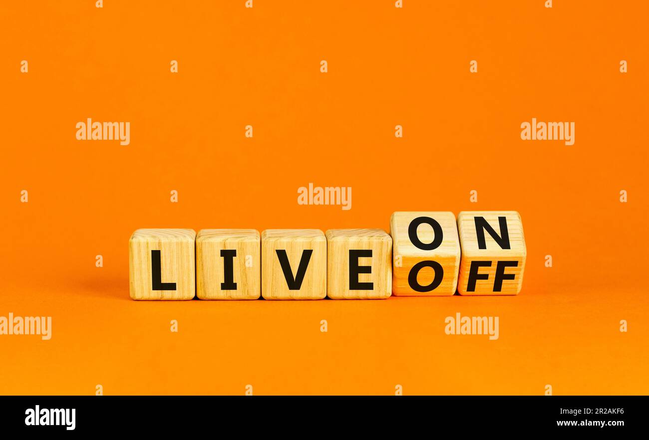 Live on or off symbol. Businessman turns wooden cubes and changes word ...
